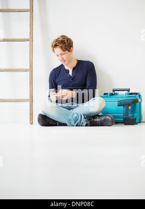 Worker on ladder with tool and toolbox Stock Photo - Alamy