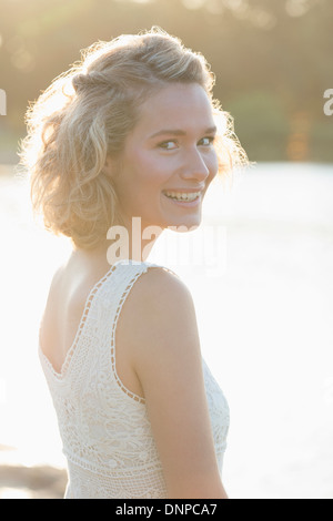 Beautiful blonde woman standing over pink background smiling cheerful ...