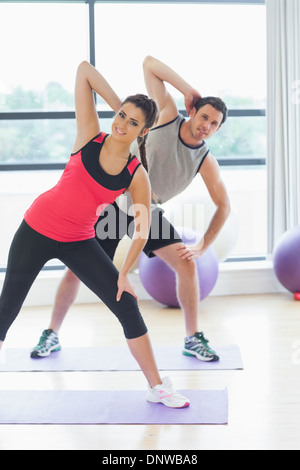 Smiling people doing power fitness exercise at yoga class Stock Photo ...