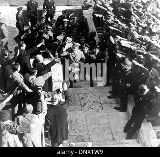 Adolf Hitler waving to crowds from his car at the head of a parade. The ...