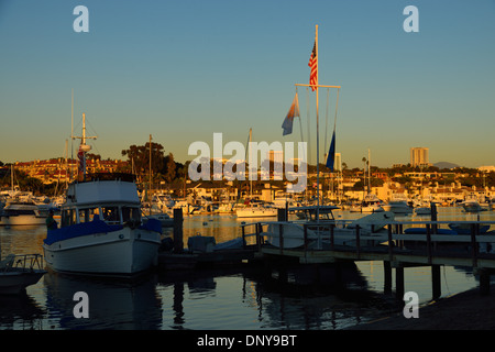 Balboa Island harbor at sunset with ships and sailboats visible from ...