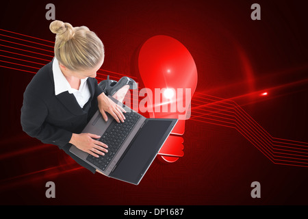 Businesswoman with laptop and glowing light bulb on orange background ...
