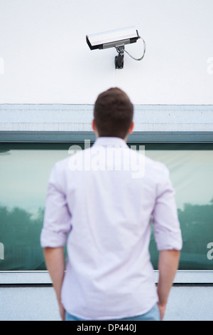 Image from back of brunet in sunglasses washing mirror sitting in car ...