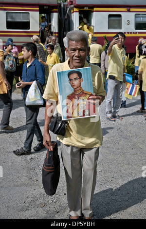 The senior Asian man with yellow t shirt standing on the blue ...