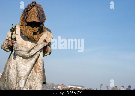 A scavenger man is carrying a sack while collecting recyclable material ...