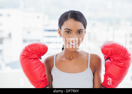 A young boxing model posing with gloves on a white background in a ...