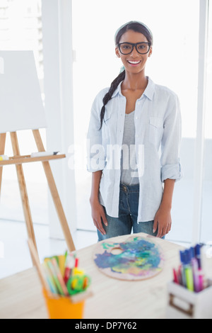 Pretty female artist smiling and posing at creative workshop with her ...