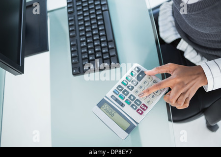Female accountant using calculator and keyboard for budgeting and ...