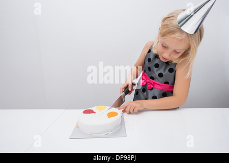 Girl cutting cake in a birthday party Stock Photo - Alamy
