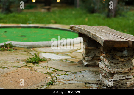 Outdoor green mini golf with bench near it Stock Photo - Alamy
