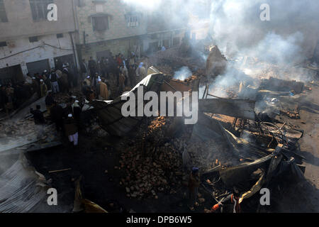 Peshawar, Pakistan. 11th Jan, 2014. A man examines the fire site in ...