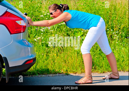 Girls pushing car Stock Photo - Alamy