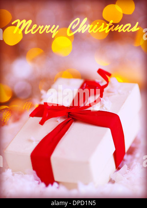 A red Merry Christmas gift box sits beside a silver present tied with a ...