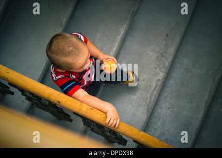 Little boy walking down stairs taking support of a wall. Small kid ...