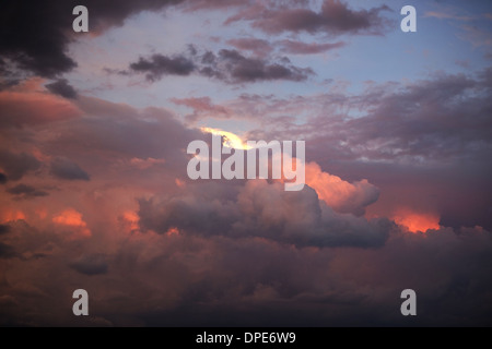 Beautiful sunset in the cloudy sky over the ocean near a stone pier ...