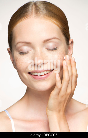 Smiling young woman applies cream on her hands Stock Photo - Alamy