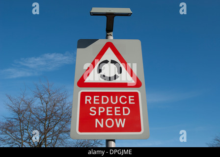 Reduce speed now roundabout ahead road sign Stock Photo - Alamy