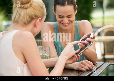 Two friends share a laugh over coffee outside a modern building ...