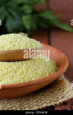 cous cous cereal in a clay bowl on wooden table Stock Photo - Alamy