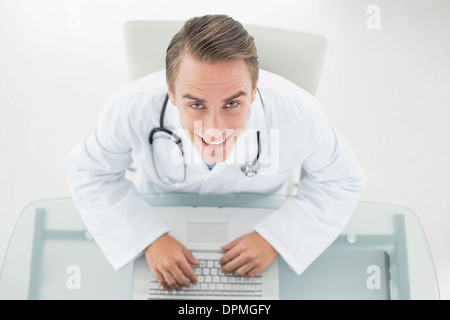 Overhead portrait of smiling doctor with laptop gesturing thumbs up ...