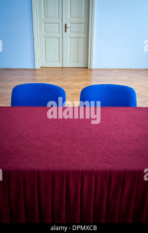 Blue chair and table with heavy burgundy colour tablecloth in a 50s ...