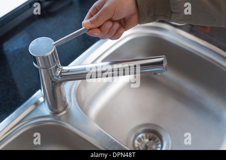 Plumbers hand opening a tap Stock Photo - Alamy