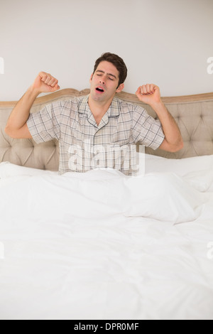Man with closed eyes stretching sitting at table Stock Photo - Alamy
