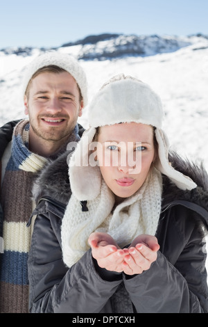 Couple with cupped hands on snow covered landscape Stock Photo - Alamy