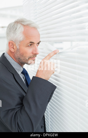 Serious mature businessman peeking in office Stock Photo - Alamy