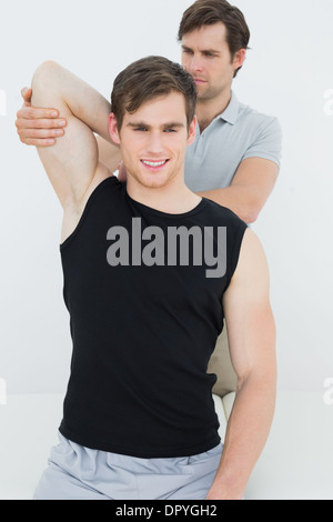 Male physiotherapist stretching a man's hand Stock Photo - Alamy