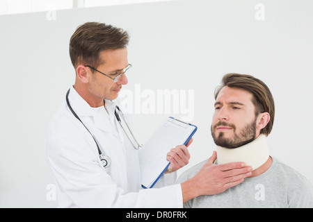 Male doctor examining a patient's sprained neck Stock Photo - Alamy