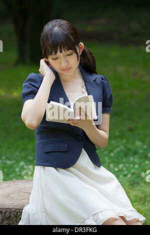 young Asian women reading book on sofa at home in comfortable living ...