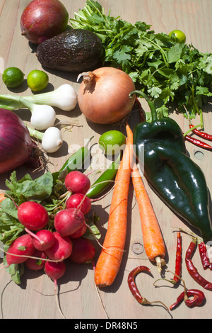 Vibrant red radishes with fresh green leaves arranged on dark textured ...