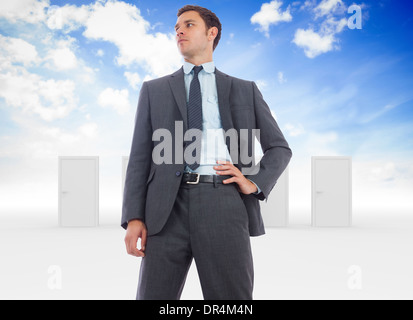 Composite image of stern businessman with hand on hip Stock Photo - Alamy