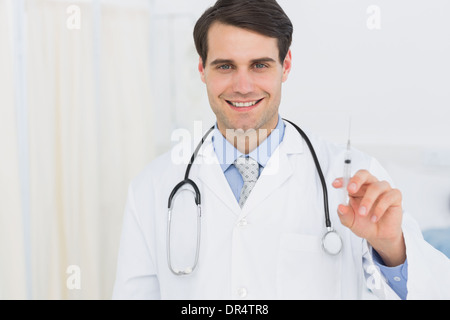 Handsome young doctor man holding paper with red heart over isolated ...