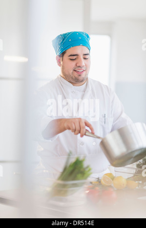 Mixed race chef cooking in restaurant Stock Photo - Alamy