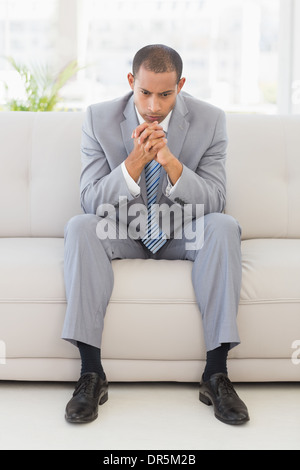 Anxious businessman sitting on couch in the office Stock Photo - Alamy