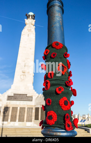 Hand crocheted and knitted red poppies on lamp post in front of the ...