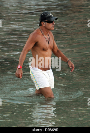 The singer Bruce Springsteen doing paddlesurf on a beach on holiday in ...