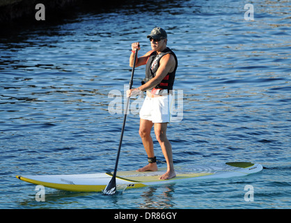 The singer Bruce Springsteen doing paddlesurf on a beach on holiday in ...
