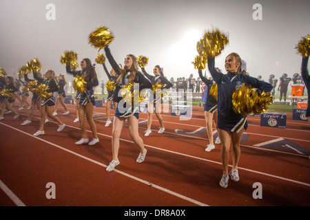 Teenage high school cheerleader and football player holding hands ...