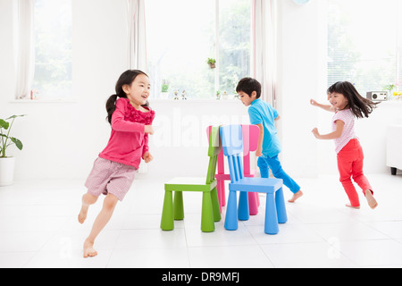 kids playing with different color chairs Stock Photo - Alamy