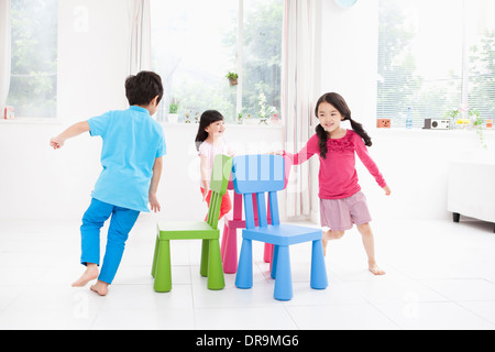 kids playing with different color chairs Stock Photo - Alamy