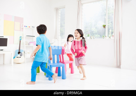 kids playing with different color chairs Stock Photo - Alamy