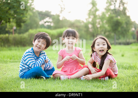 kids sitting on the grass Stock Photo - Alamy