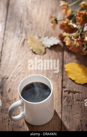 Autumn flowers and a Cup of coffee on a wooden background with a copy ...