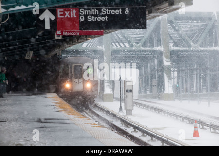 Train arrives on elevated subway station covered in snow during Sunday ...