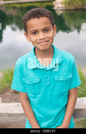 Smiling boy in casual t-shirt counting eight with fingers isolated over ...