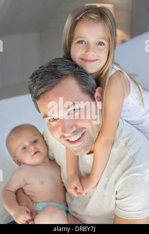 Smiling boy embracing brother holding toy airplane on autumn leaves ...