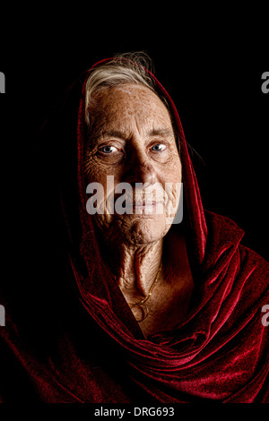 Meditating senior woman in red leggings sitting with man in gray on ...